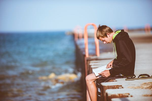 Free: boy sitting on dock while reading - nohat.cc