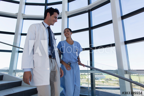 Free: Doctor and nurse talking on modern hospital staircase - nohat.cc