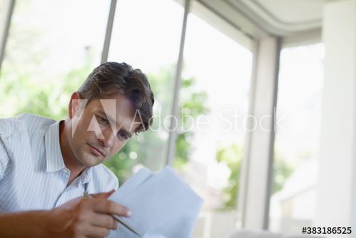 Free: Focused man reading paperwork - nohat.cc
