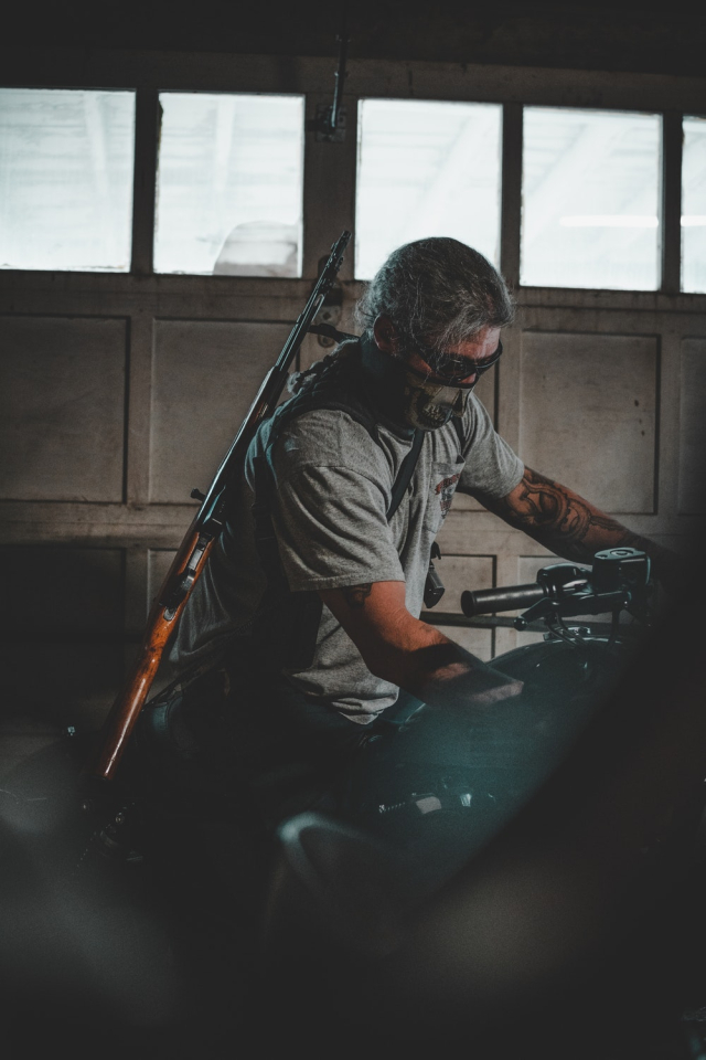 Free: Man With Rifle Standing Near Motorcycle - nohat.cc
