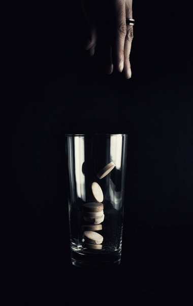 Free: Person Drop Tablets on Clear Drinking Glass on Black Surface ...
